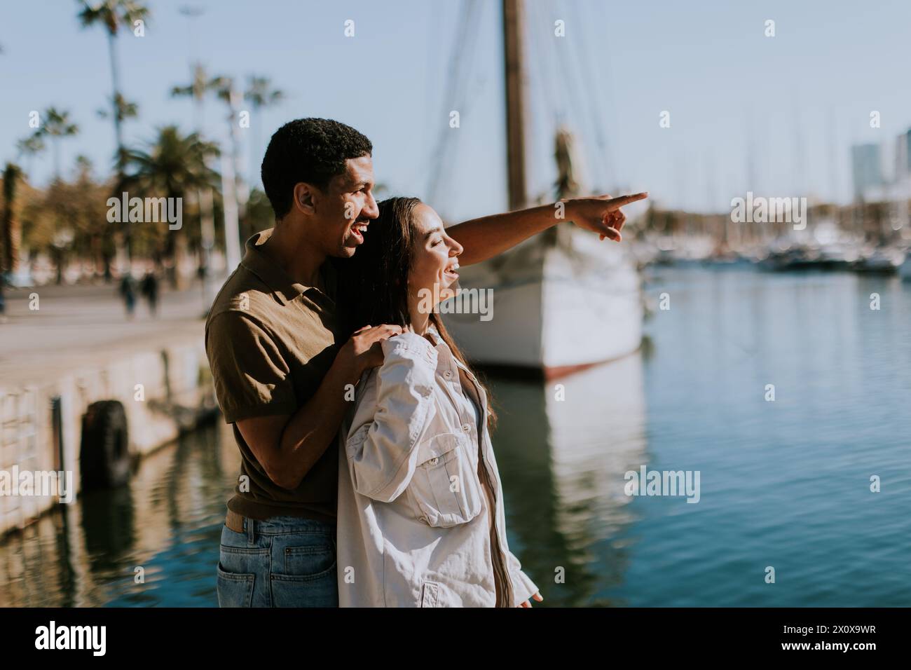Young couple embraces while exploring the enchanting seaside atmosphere ...