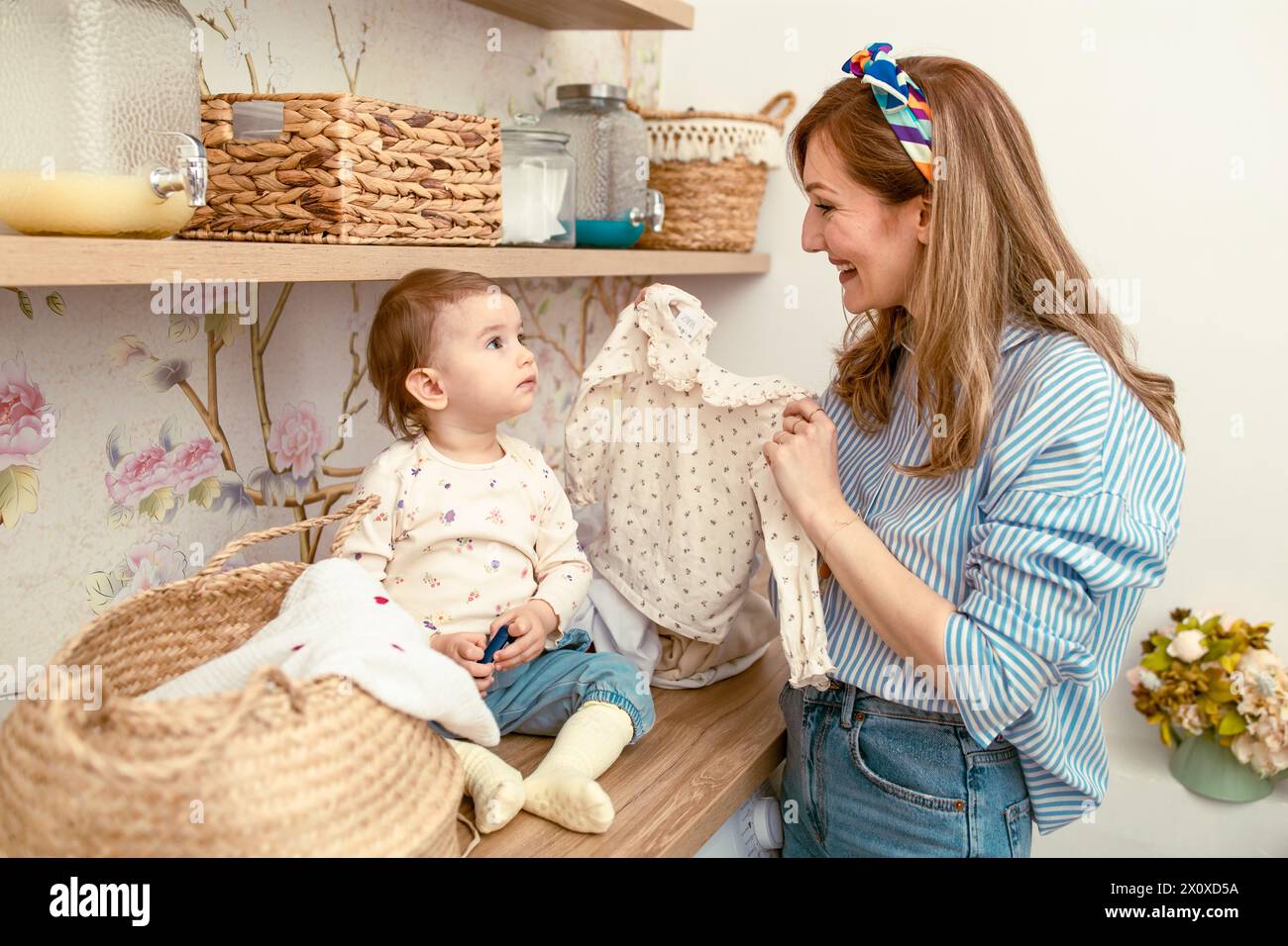 Mom showing her daughter clean washed clothes. Mothers day Stock Photo ...