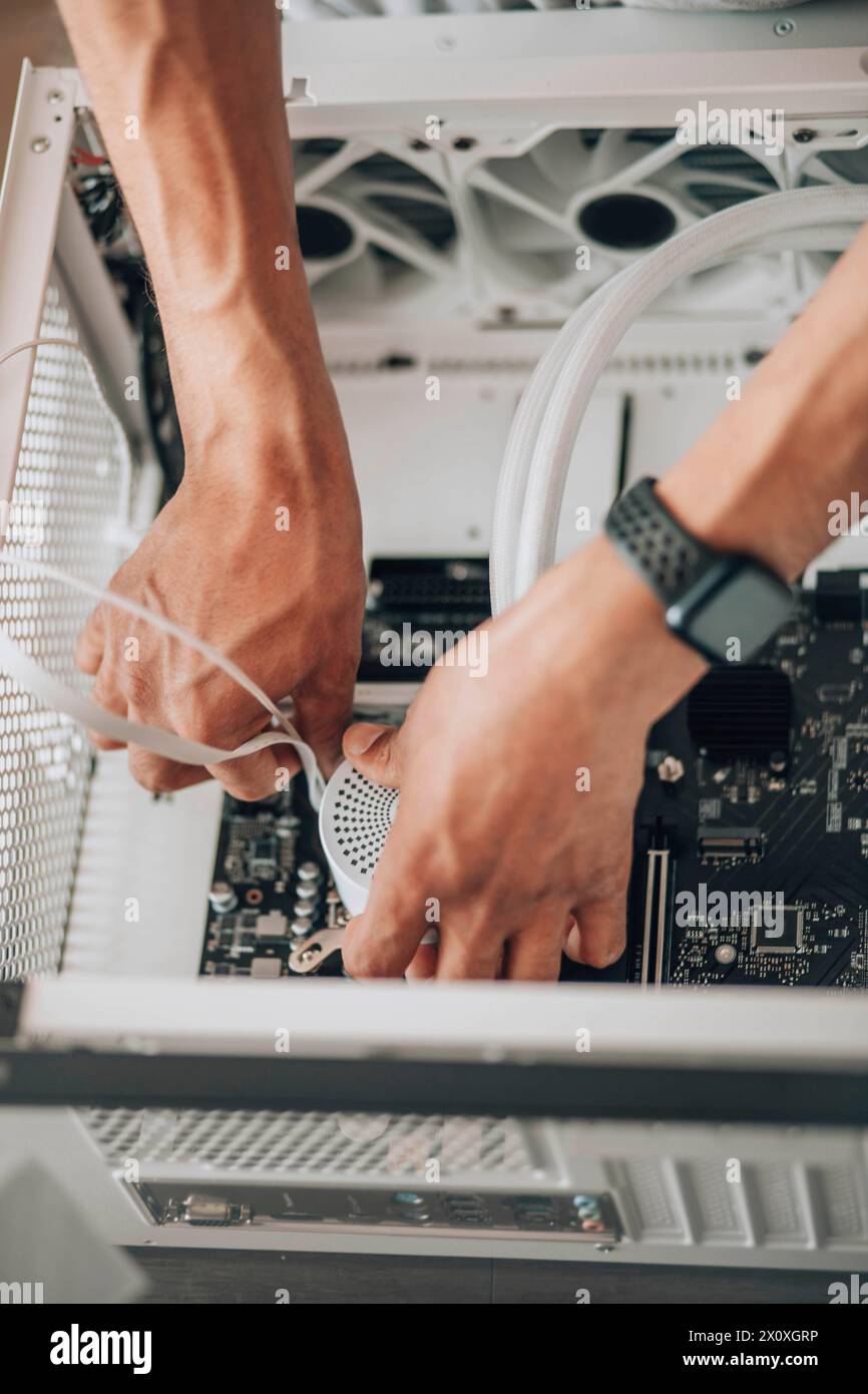 hands orchestrating the assembly of a computer fan, symbolic of the ...