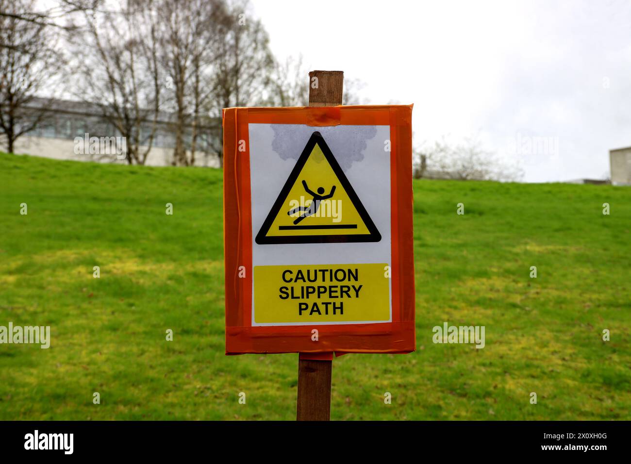 Temporary makeshift Caution Slippery Path signpost on a rural footpath ...