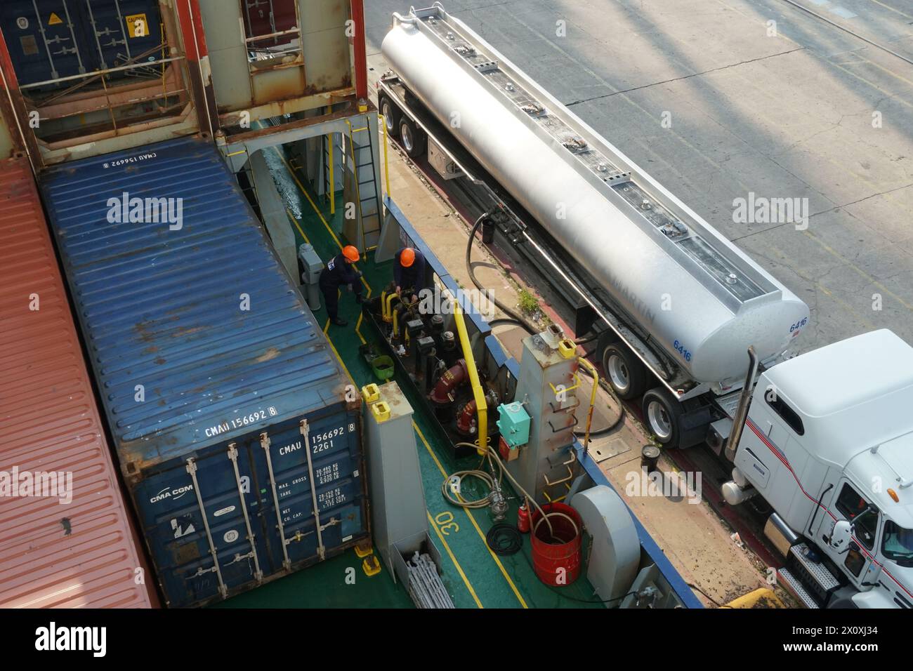 View on fuel hose from tanker truck connected to container vessel in ...