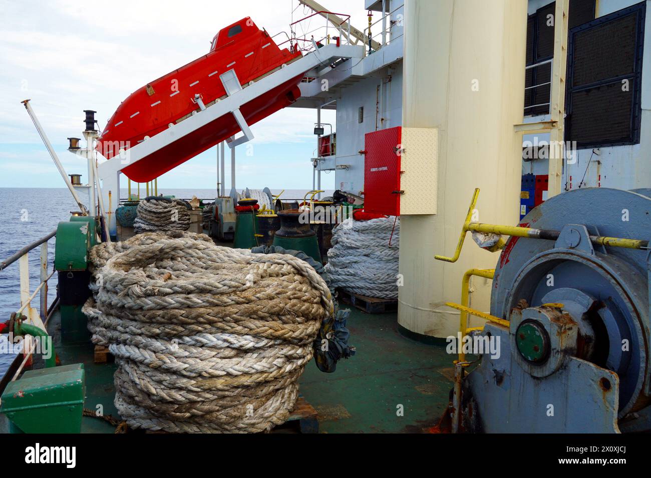 Orange free fall lifeboat secured on white launching ramp and ready to ...
