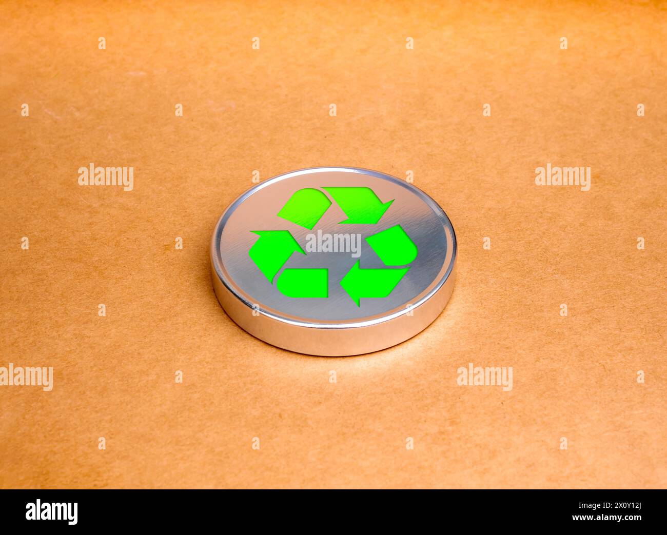 Green recycle icon symbol on round silver plate on brown kraft paper ...