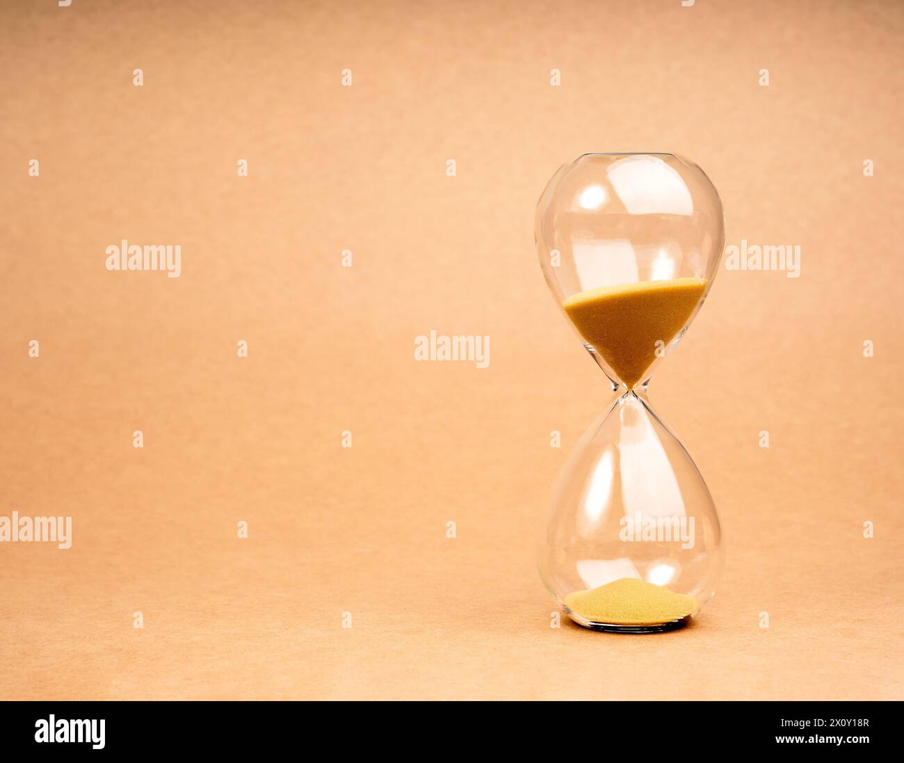 Hourglass on light brown recycled paper background with copy space ...