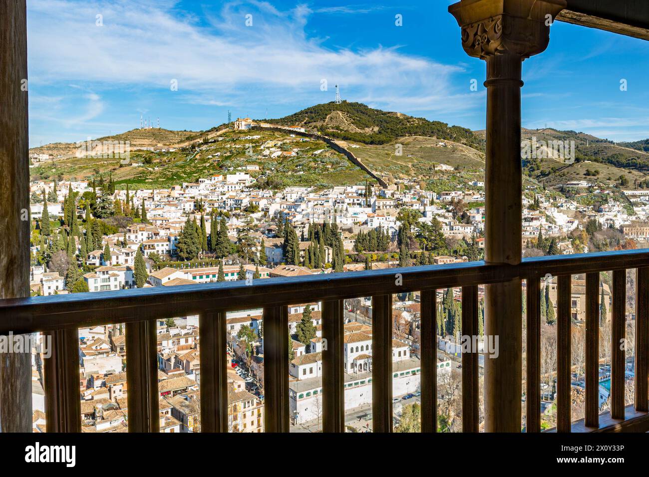 Cityscape of Granada with a hill in background against blue sky, houses ...