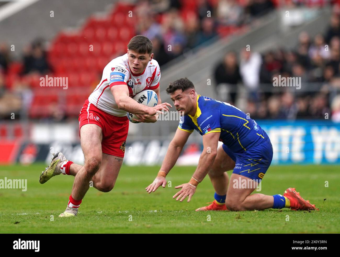 St Helens' Jack Welsby (left) evades Warrington Wolves' Joe Philbin ...