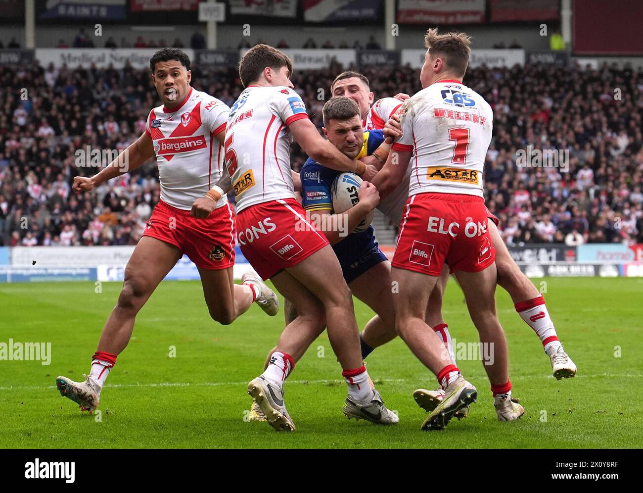 Warrington Wolves' Connor Wrench (centre) tackled by St Helens' John ...