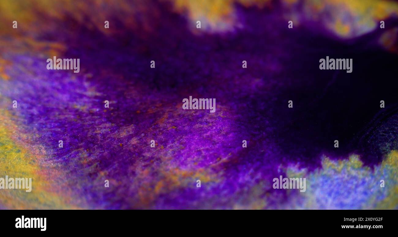 Shiny fluid spill. Glitter ink leak. Defocused black purple yellow ...