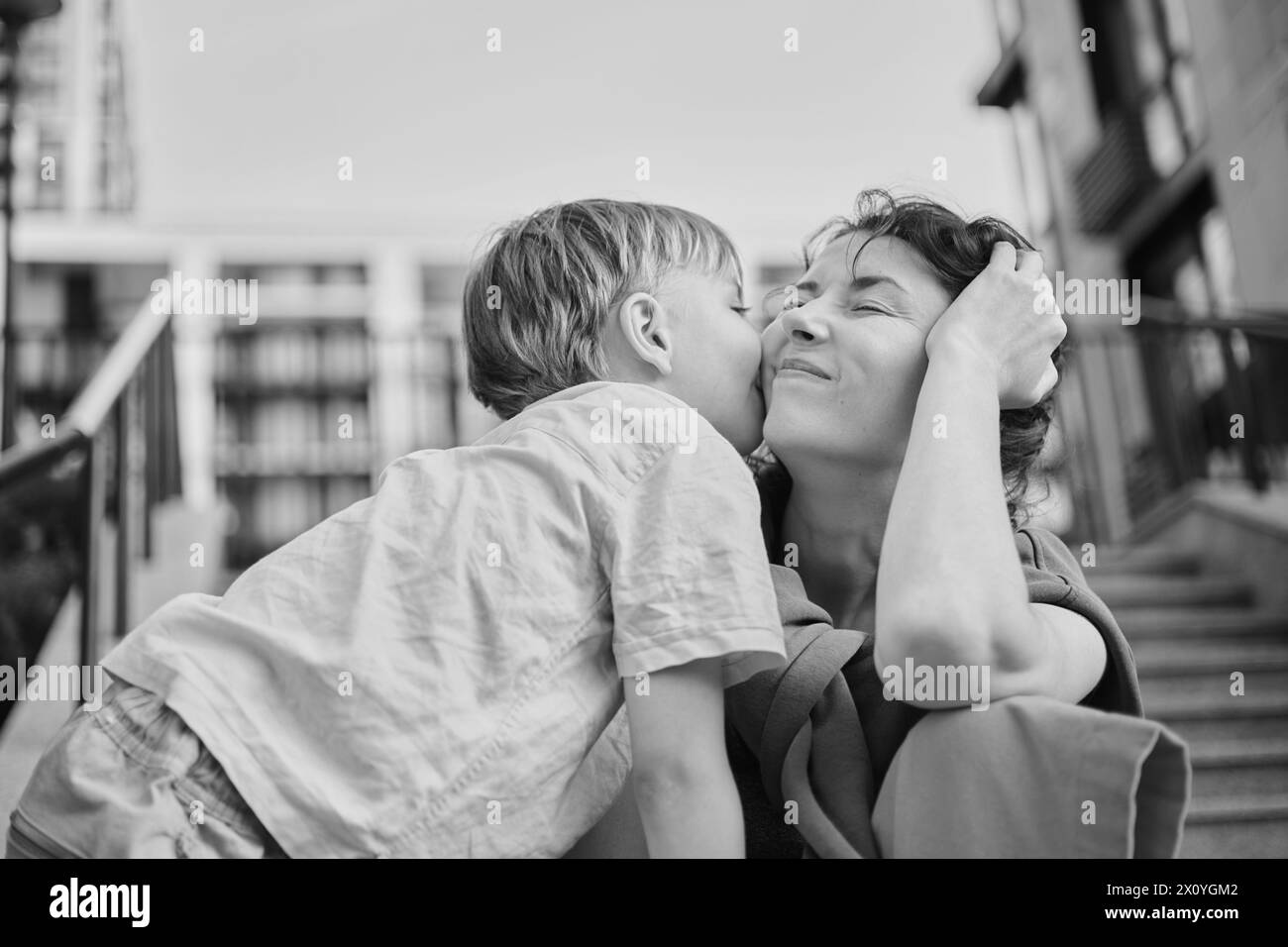 Happy family: mother and child son hugging and laugh sitting on the ...