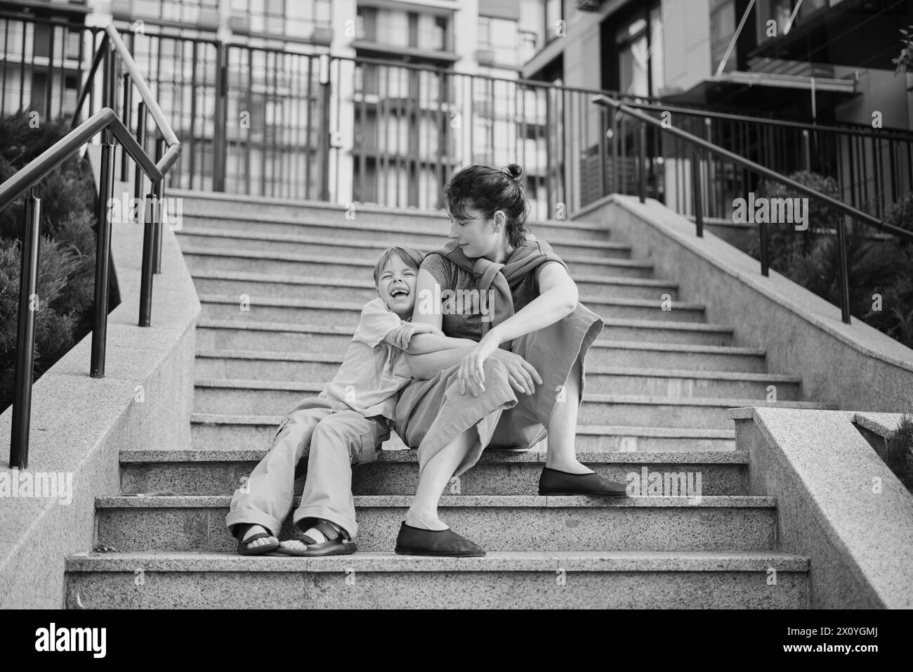 Happy family: mother and child son hugging and laugh sitting on the ...