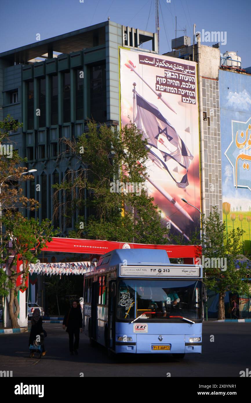 Tehran, Iran. 14th Apr, 2024. A bus stops near an anti-Israel billboard ...