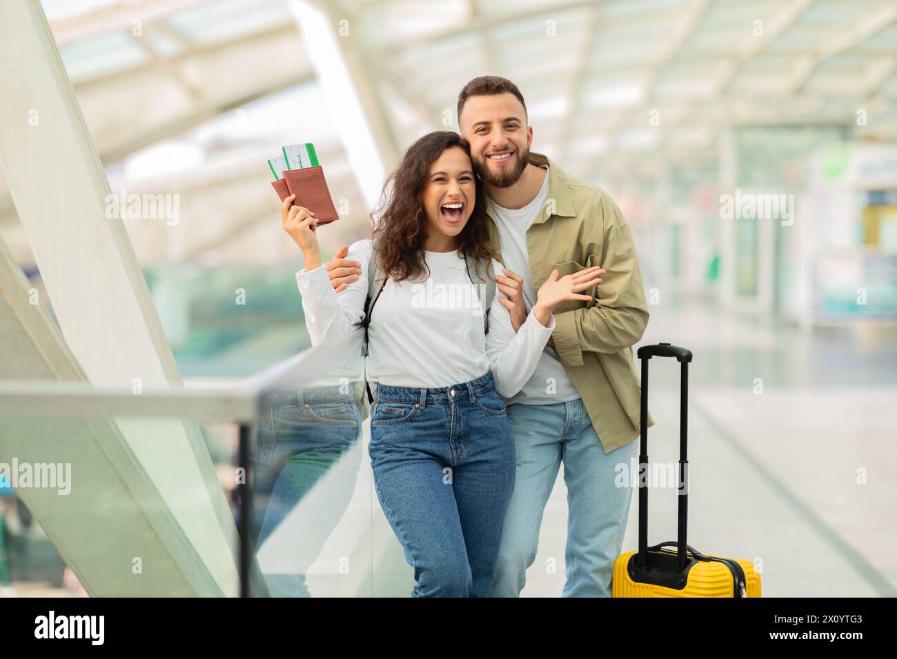 Excited Young Man And Woman Having Fun At Airport While Waiting Flight ...