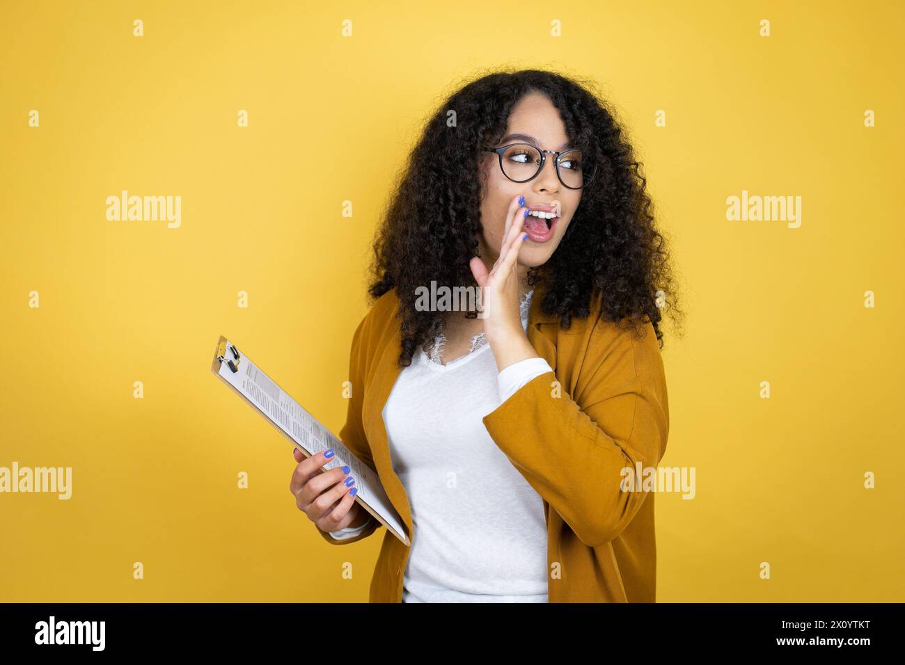 African american business woman with paperwork in hands over yellow ...