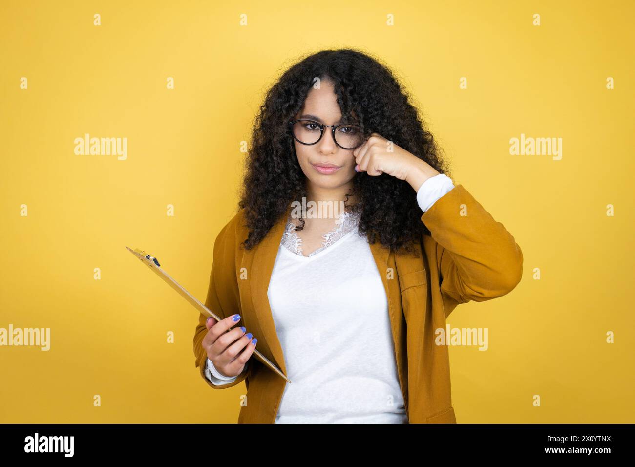 African american business woman with paperwork in hands over yellow ...