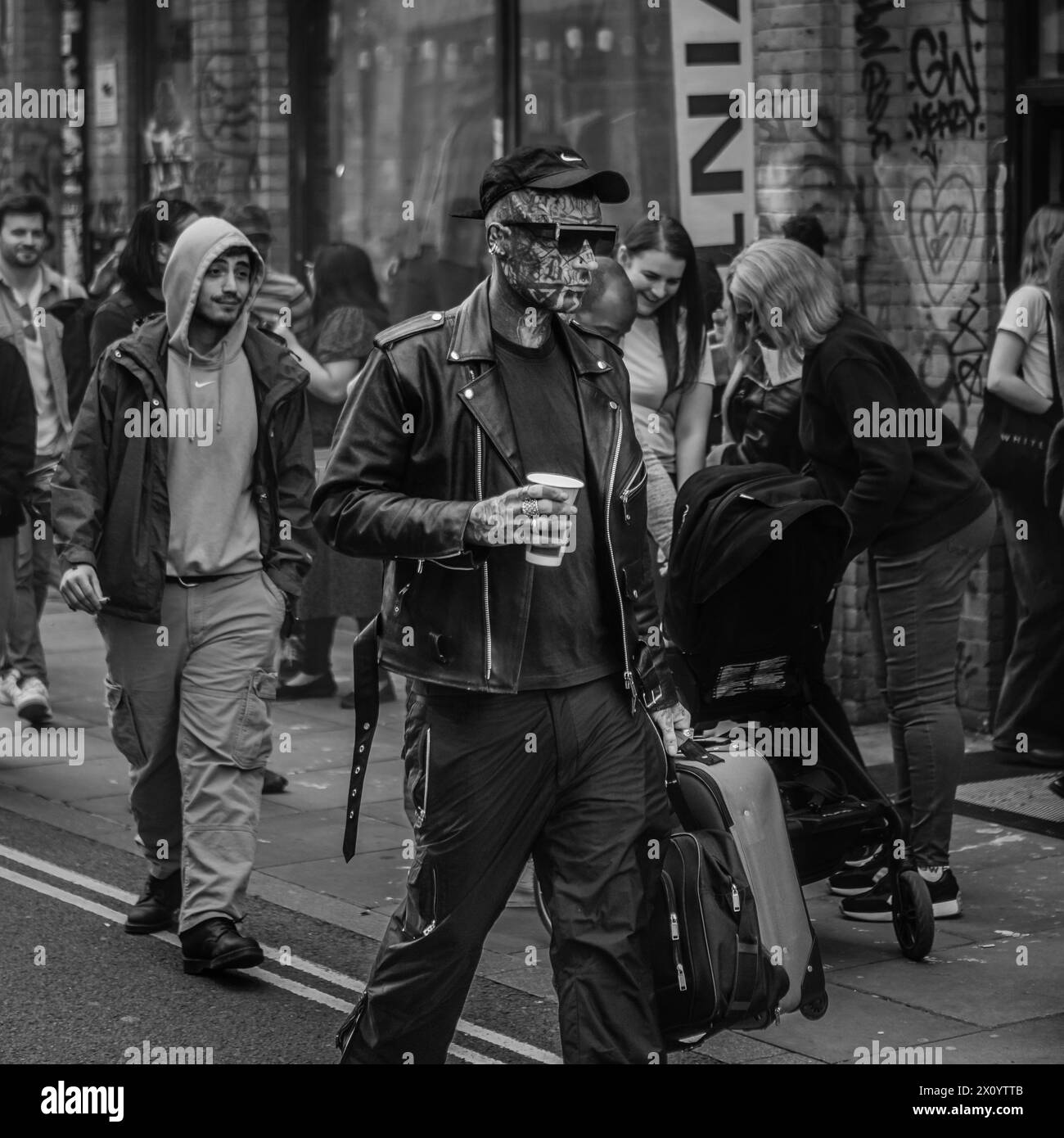 A black and white image of a man with facial tattoos standing out in ...