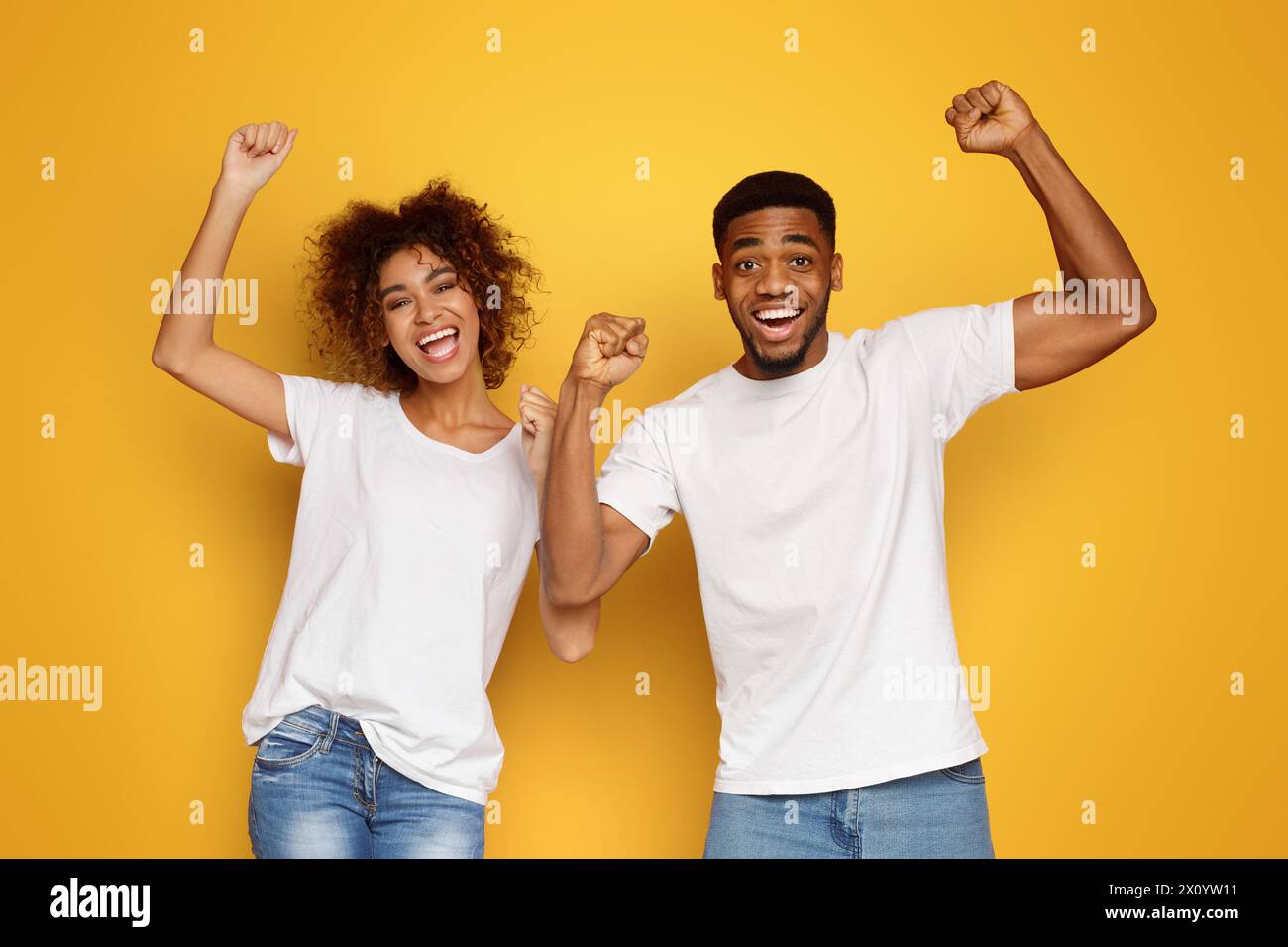 African-american partners rejoice success together on orange background ...