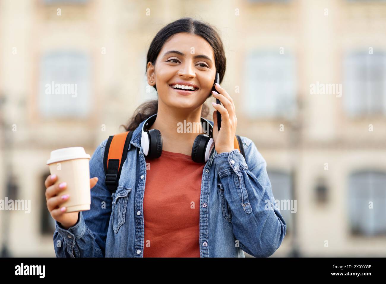 Indian student talking on phone with coffee Stock Photo - Alamy