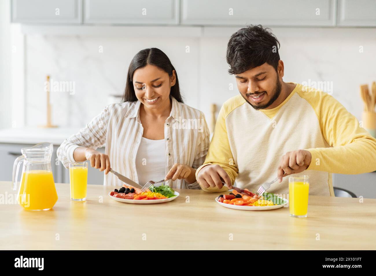 Couple eating healthy meal together happily at kicthen Stock Photo - Alamy
