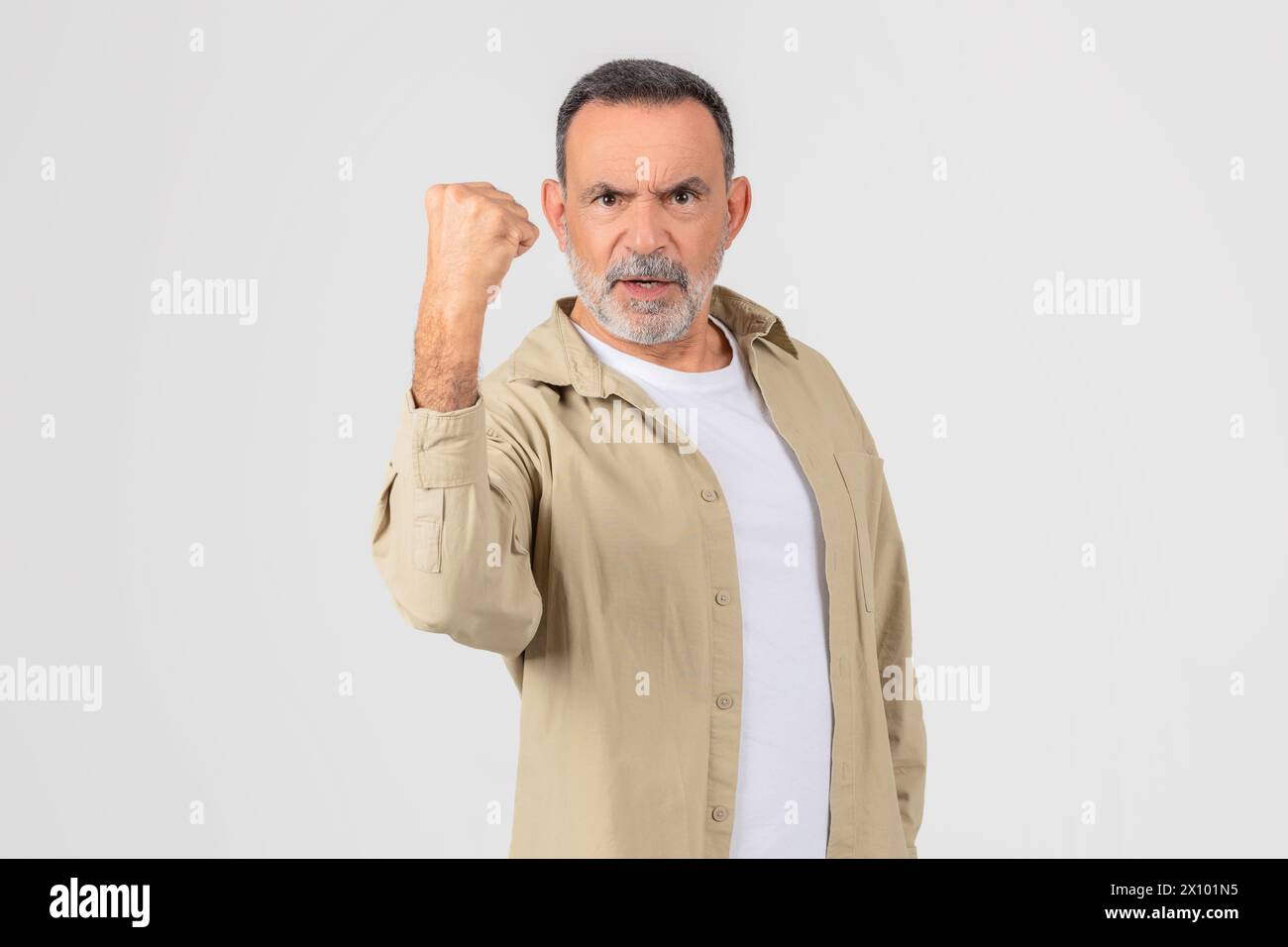 Determined senior man making a fist on white background Stock Photo - Alamy