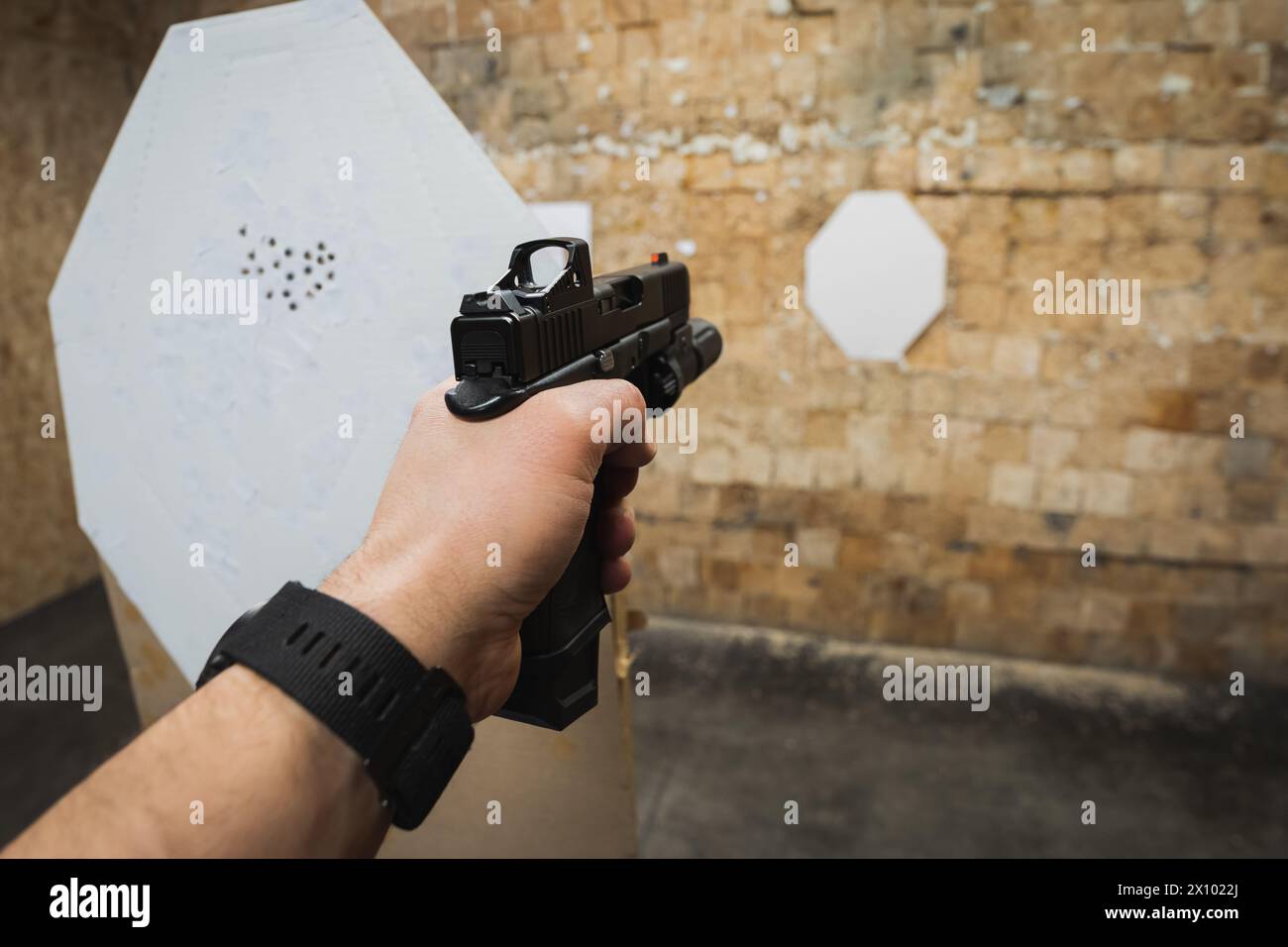 Shooting from a tactical pistol at targets in a shooting range, first ...