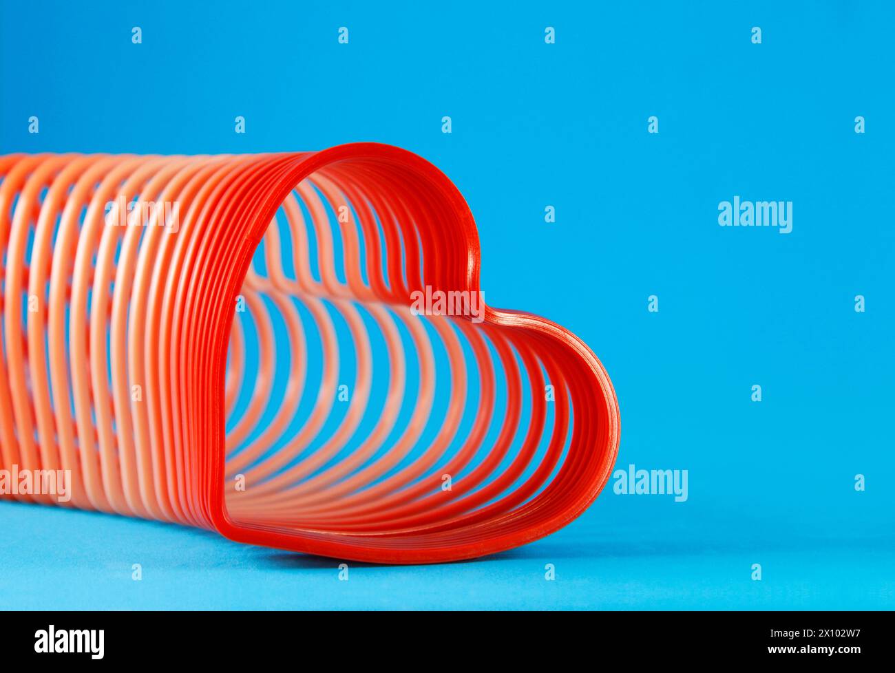 Journey of colorful heart shaped plastic spring Stock Photo - Alamy