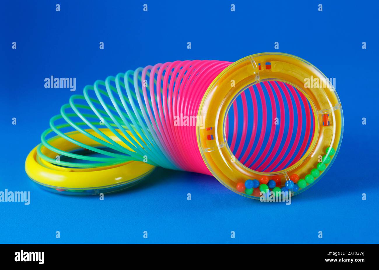 Journey of a colorful cylindrical shaped plastic spring Stock Photo - Alamy