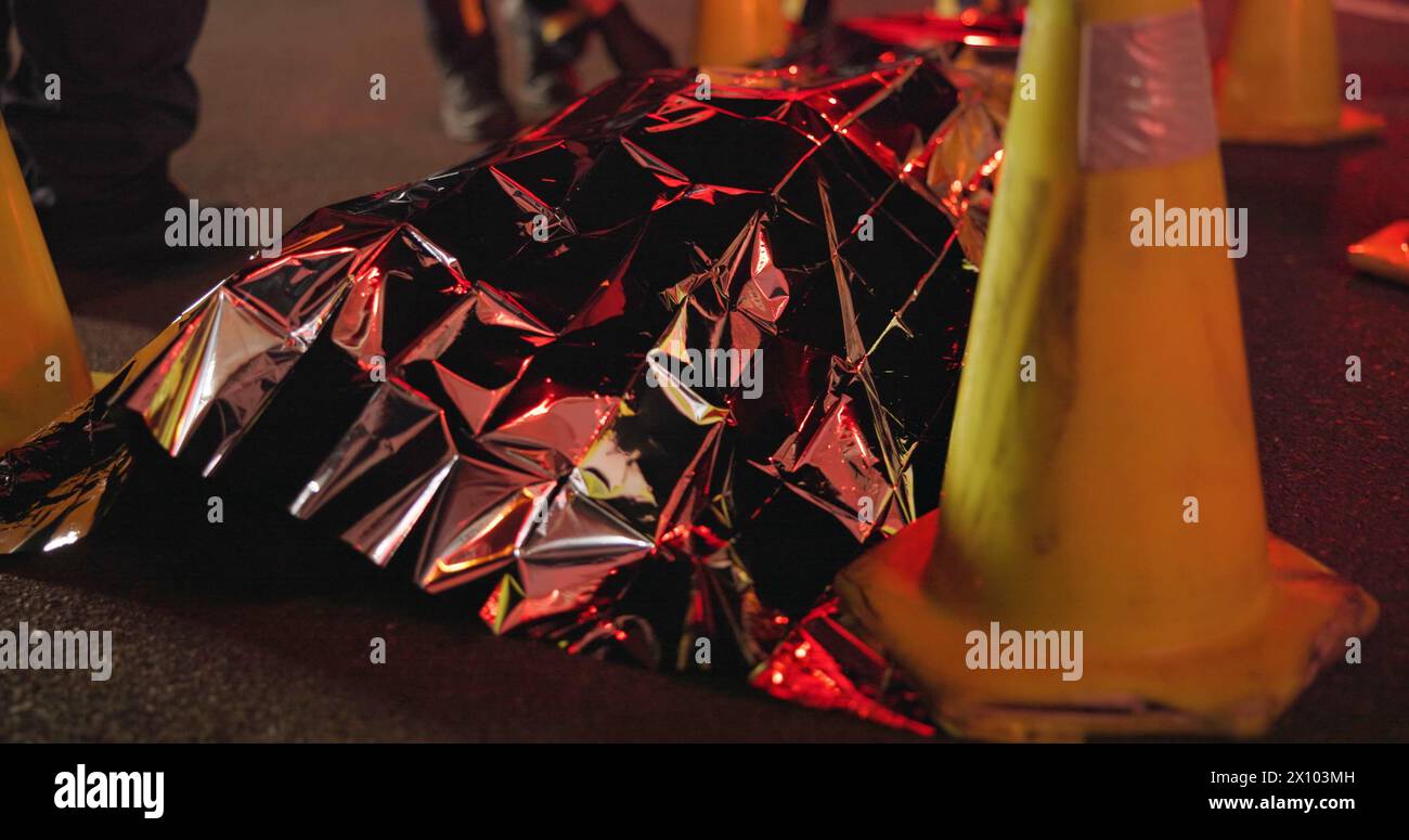 Crime scene, dead body and accident at night in road with silver cover ...