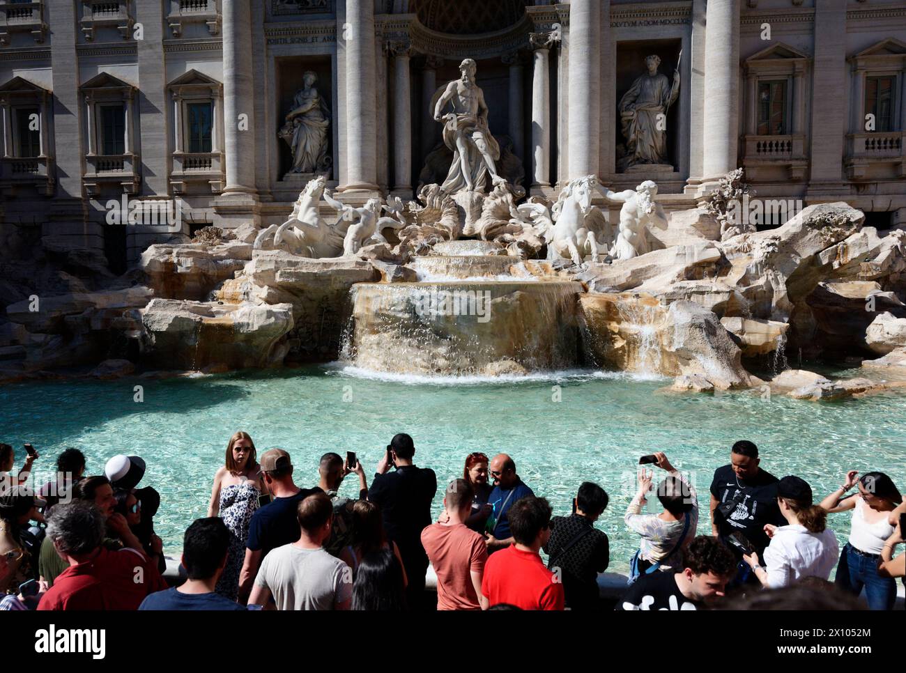Tourists are shooting photos and throwing coins into the Trevi Fountain ...
