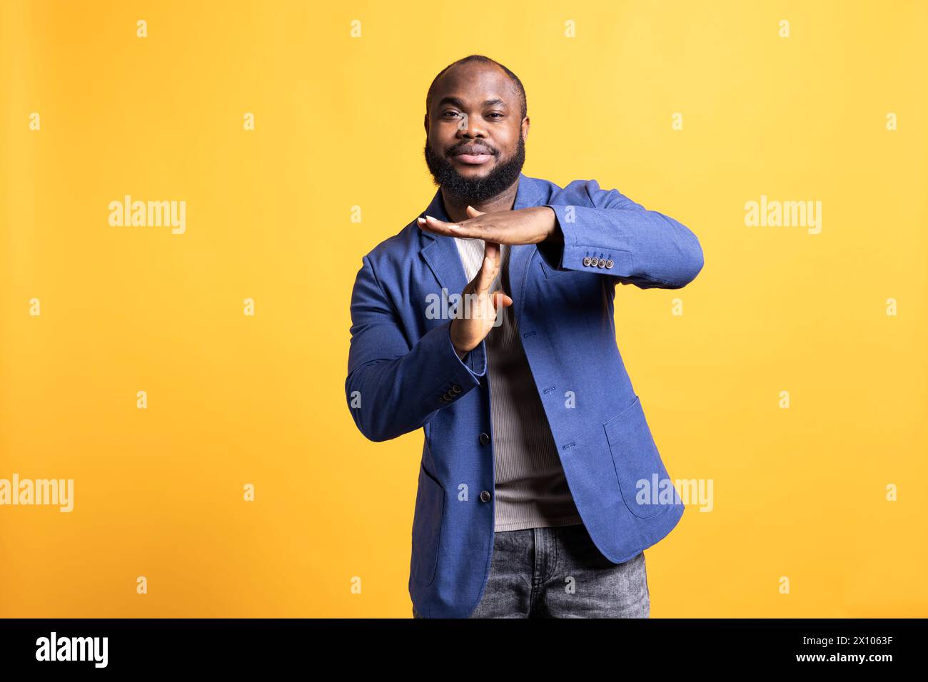 Portrait of smiling african american man asking for timeout, doing hand ...