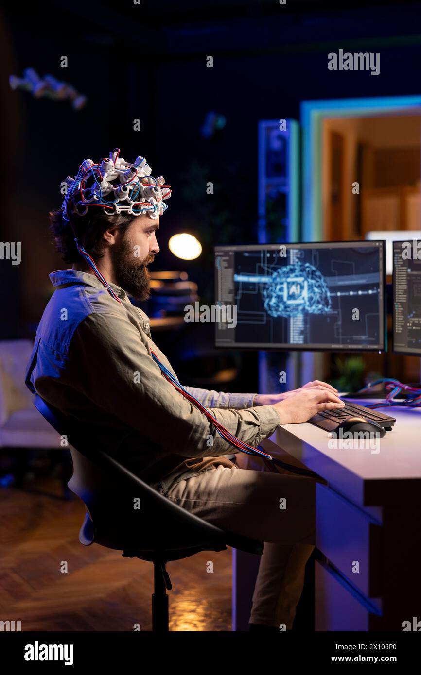 Computer engineer with EEG headset on writing code allowing him to transfer mind into virtual ...