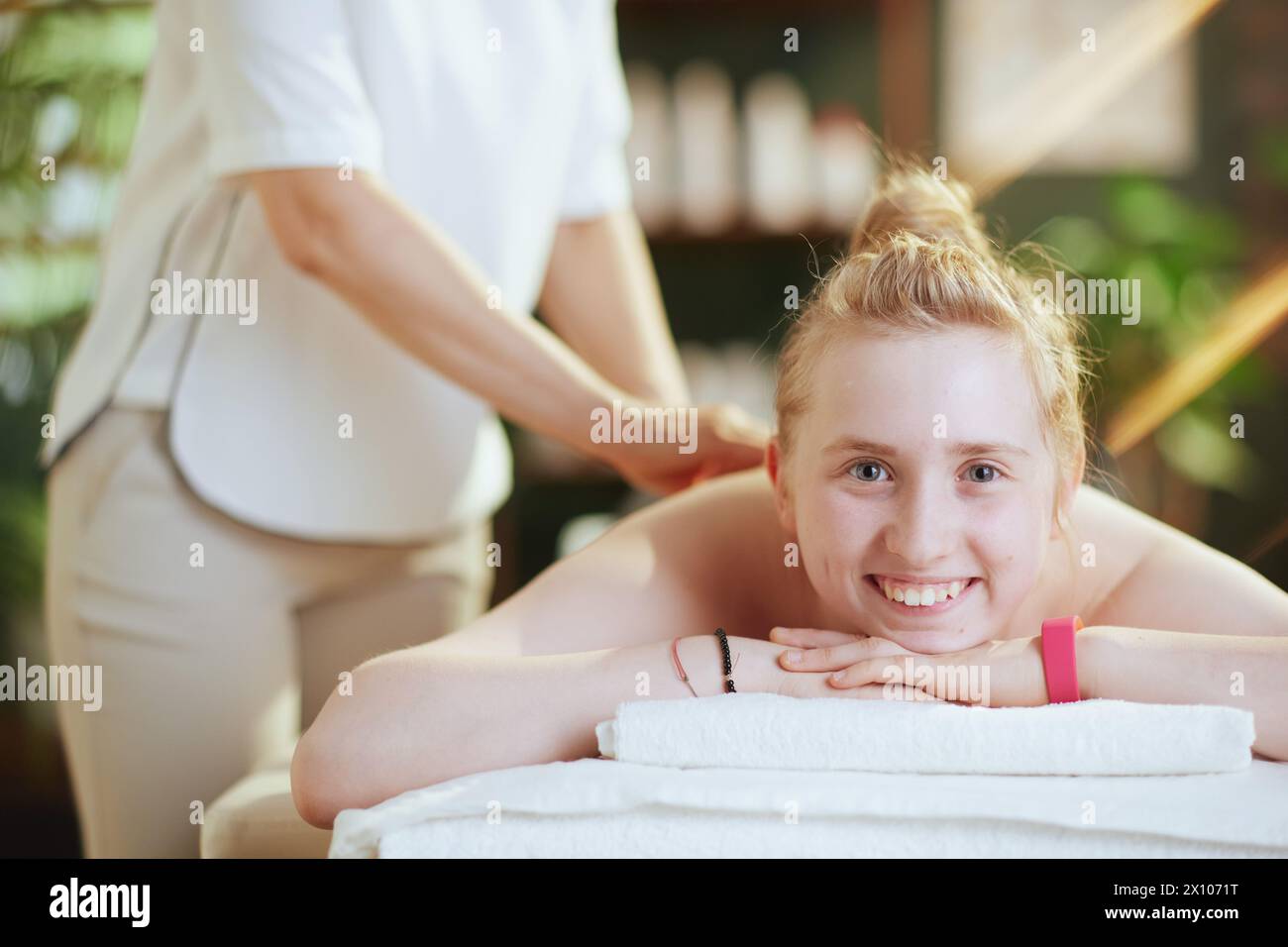 Healthcare time. female medical massage therapist in massage cabinet with teenage client making ...