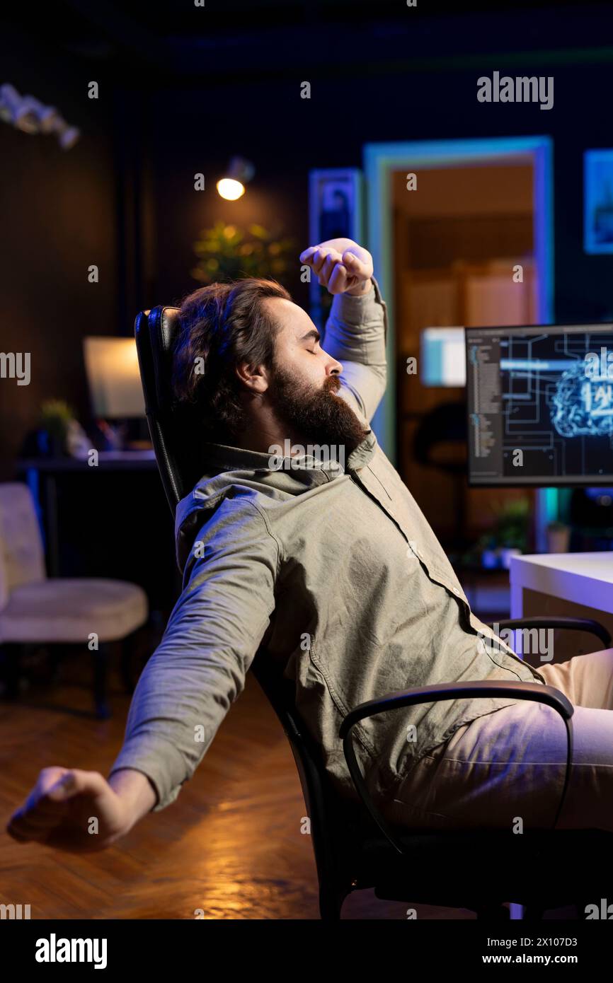 Software technician stretching after using computer all day to build ...