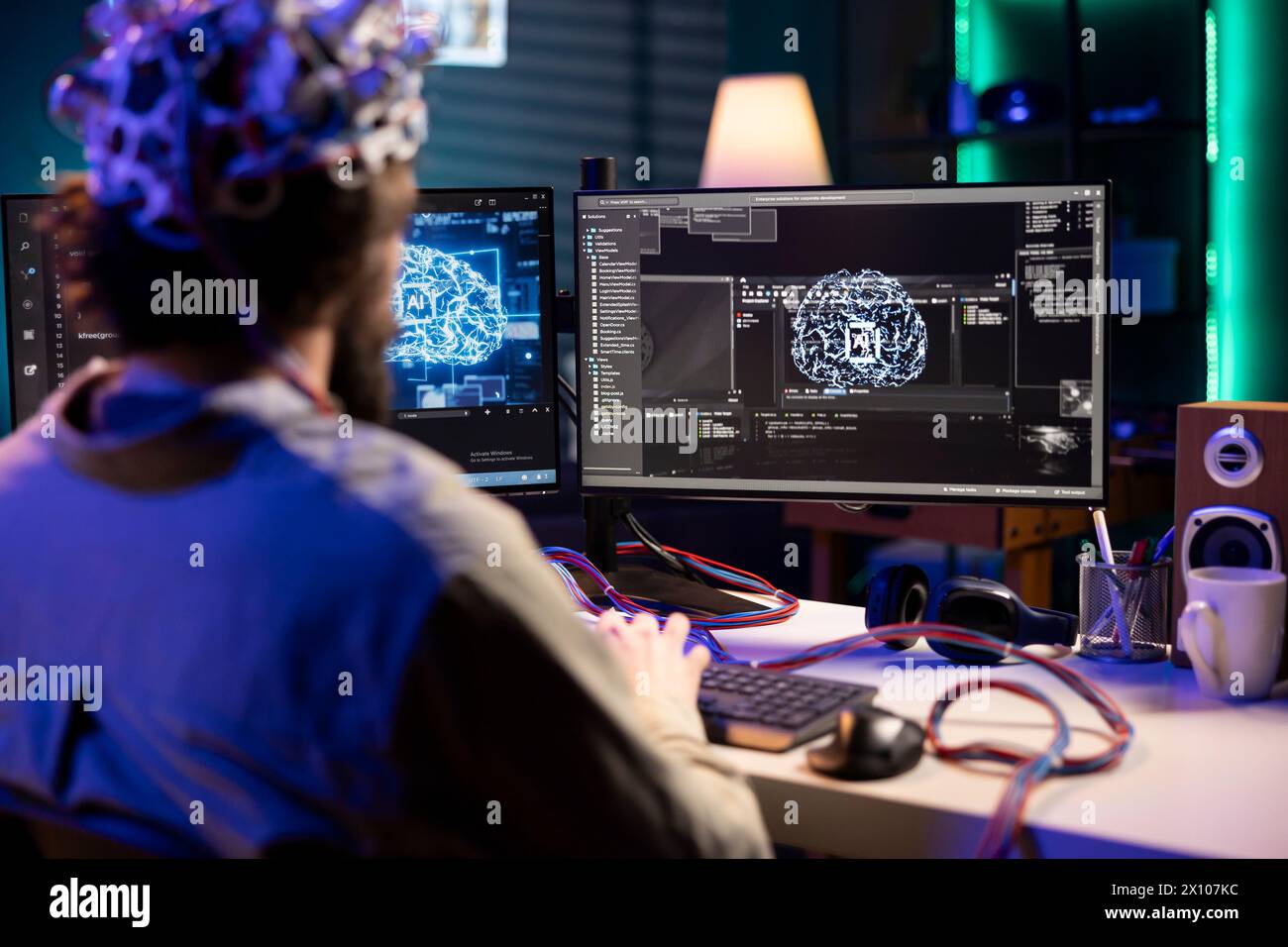 Software technician using EEG headset gear translating thoughts into PC commands using brainwave ...