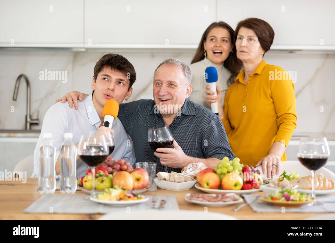 Laughing family singing together, parents and adult children having ...