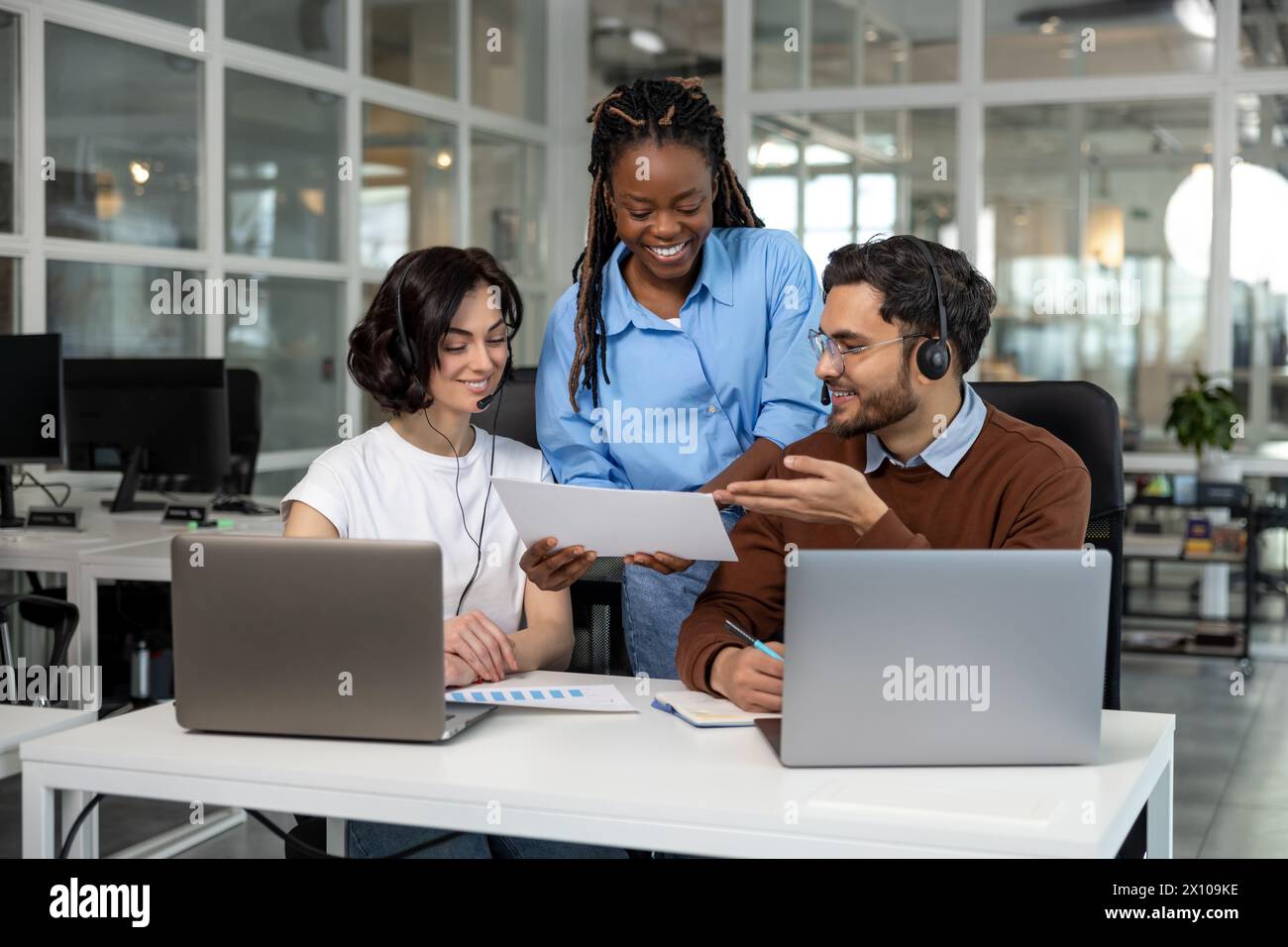 Team working on new project discussing ideas using laptops Stock Photo ...