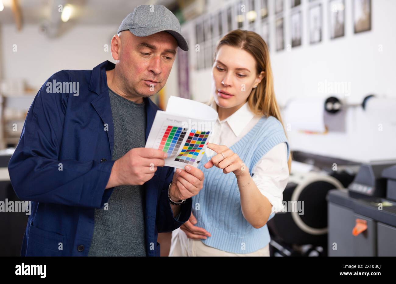 Service engineer and office worker checking color chart test page ...