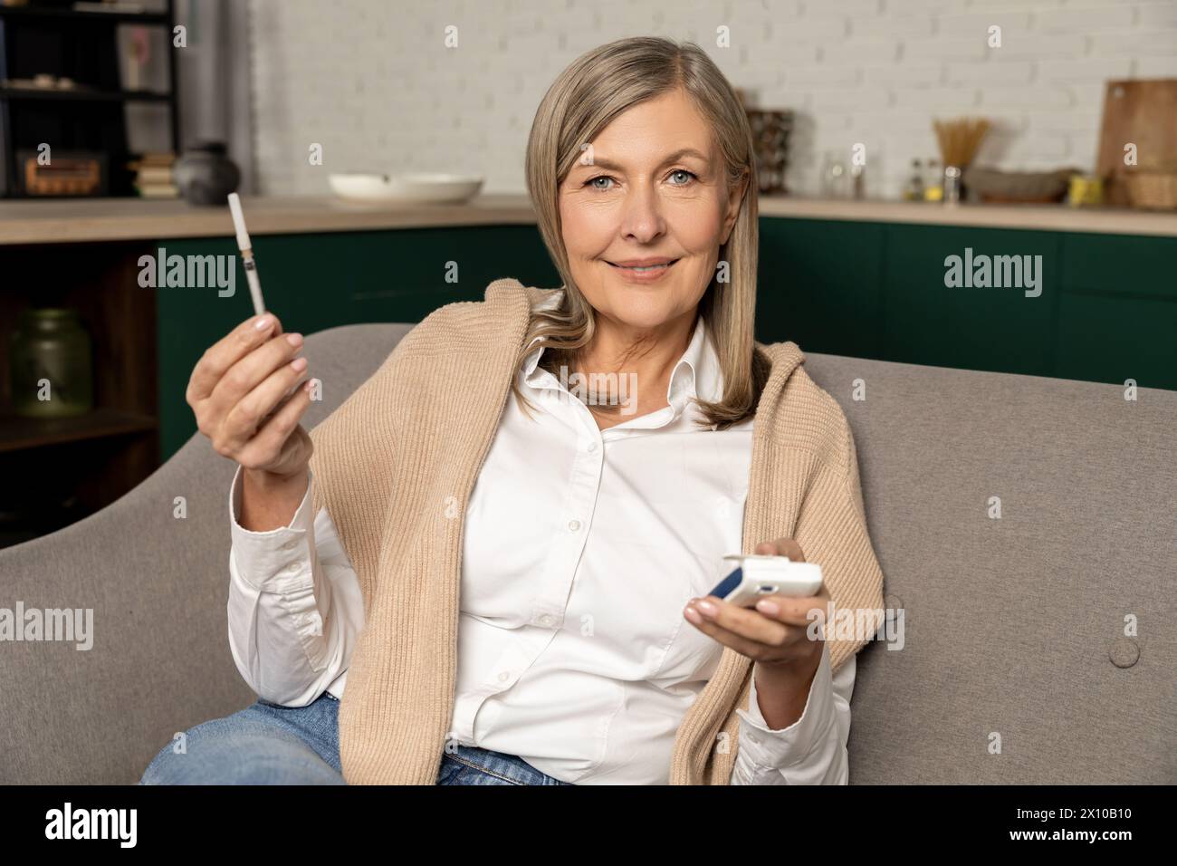 Smiling mature caucasian diabetic woman with insulin syringe in hands ...