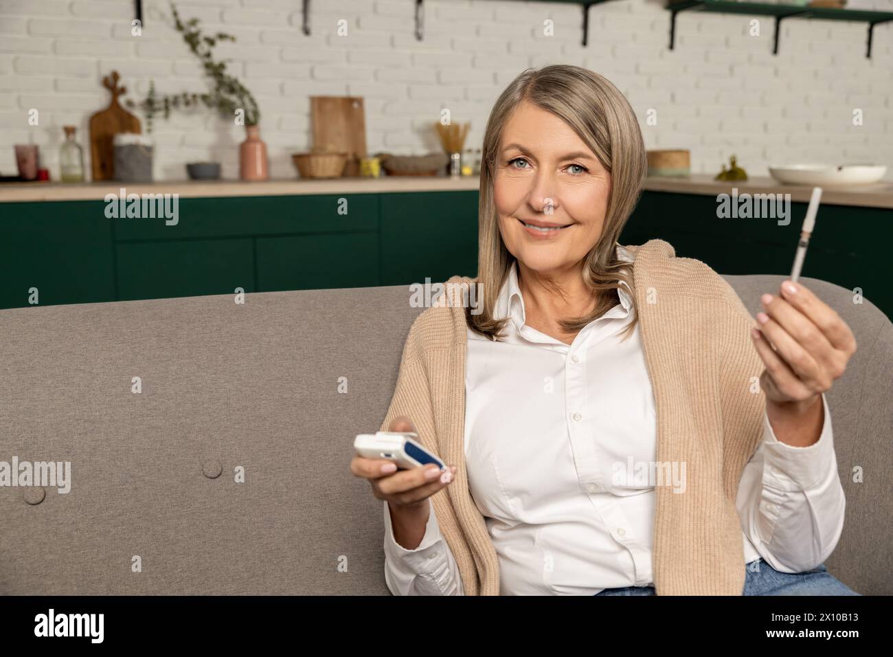 Smiling mature caucasian diabetic woman with insulin syringe in hands ...