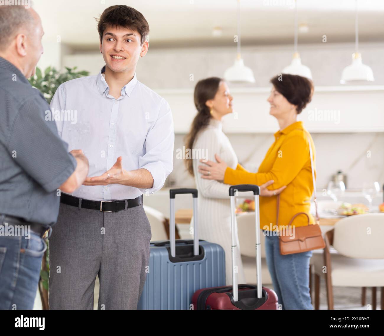 Young guy greeting father-in-law returning home from trip Stock Photo ...