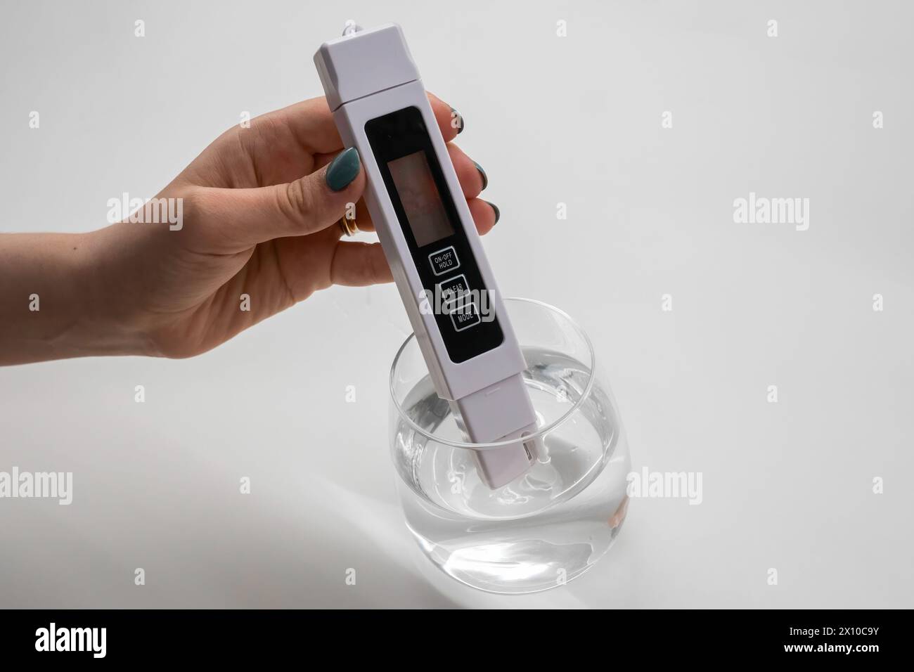 Woman uses a digital conductivity meter to check the purity of water ...