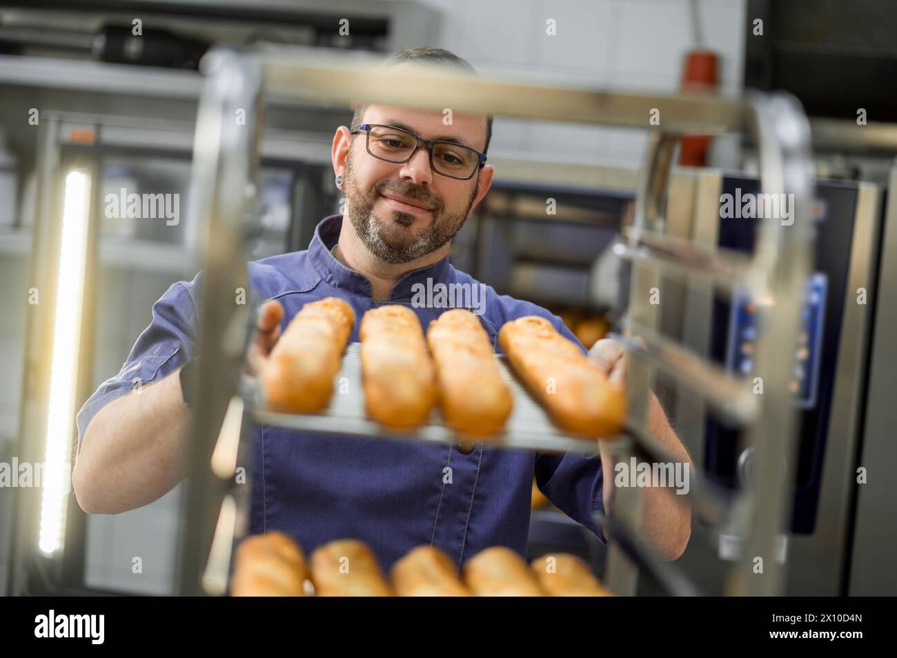 Professional baker at bakery with bread baguette Stock Photo - Alamy