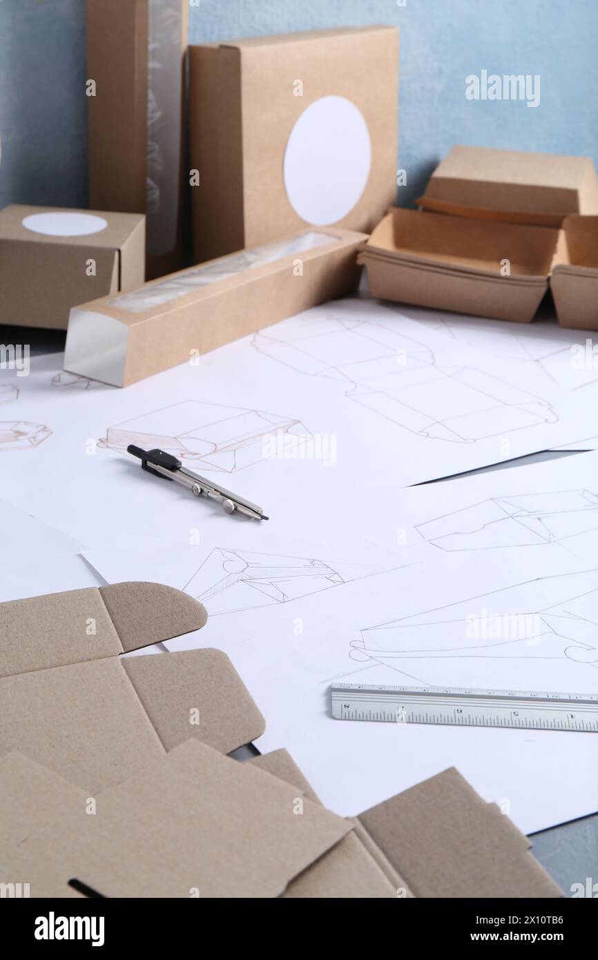 Creating packaging design. Drawings, boxes and stationery on table ...