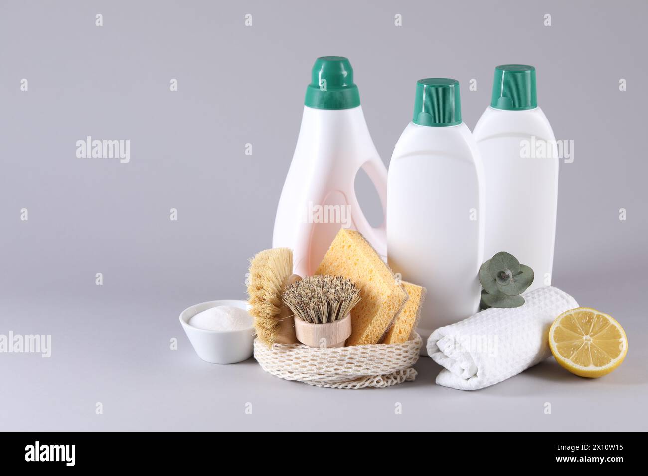 Bottles of cleaning product, sponges, brushes, lemon and baking soda on ...