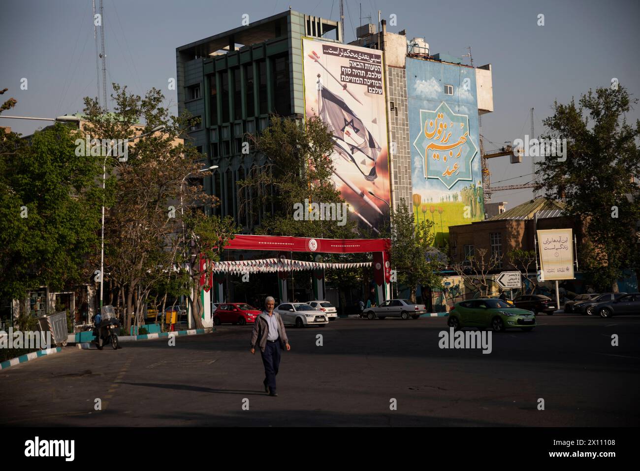 a man walks past an anti-Israeli banner on a building at the Felestin ...