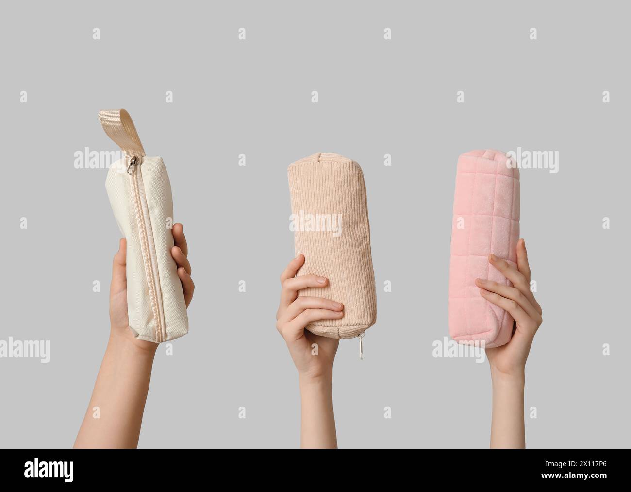 Child's hands with colorful pencil cases on grey background Stock Photo ...