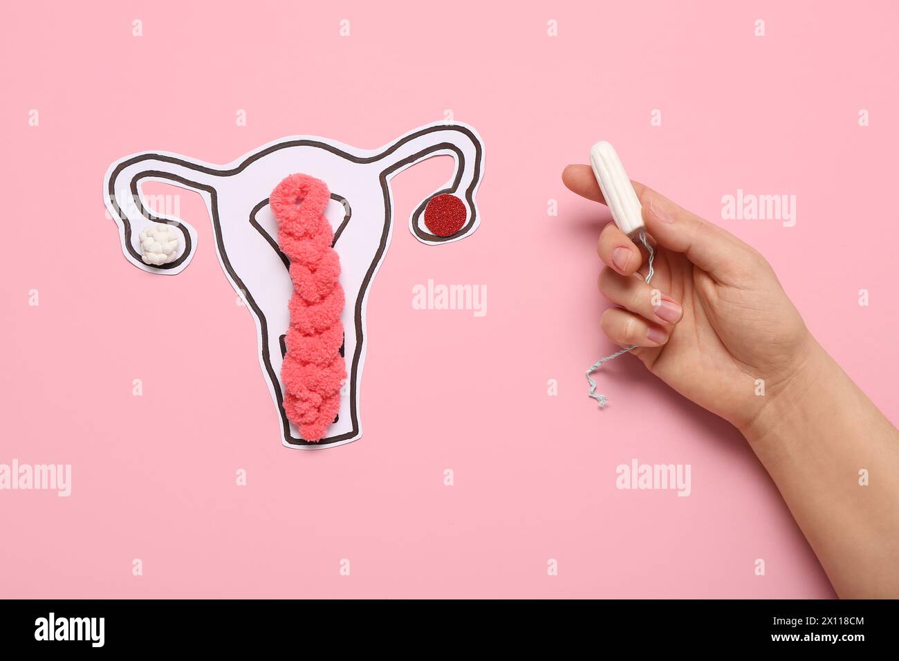 Female hand with paper uterus and tampon on pink background Stock Photo ...