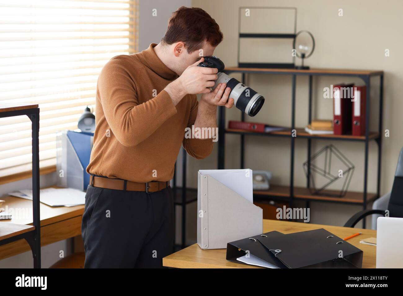 Male spy with photo camera in office Stock Photo - Alamy