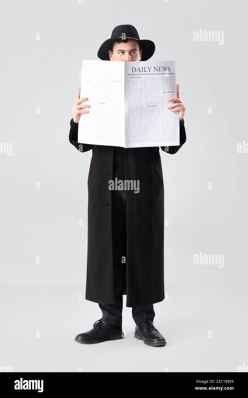 Male spy with newspaper on light background Stock Photo - Alamy
