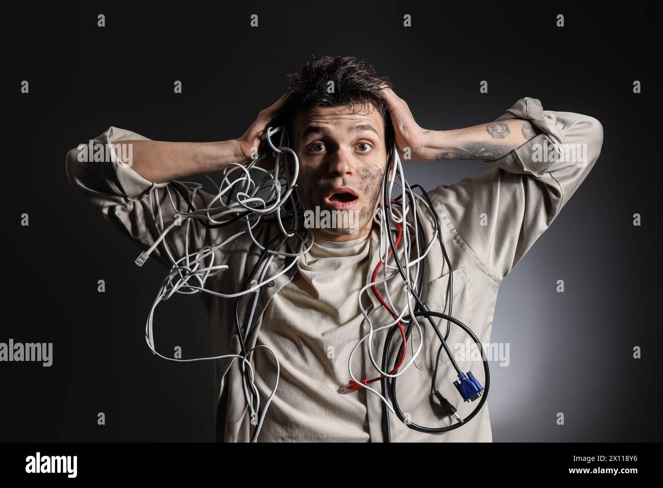 Electrocuted young man with burnt face and wires on dark background ...