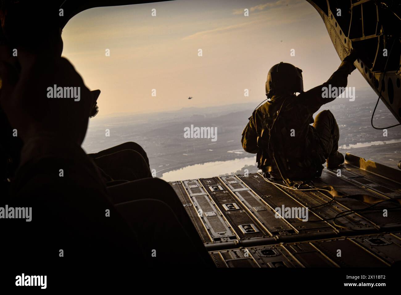 A CH-47 Chinook crew chief looks over the landscape on Camp Humphreys ...